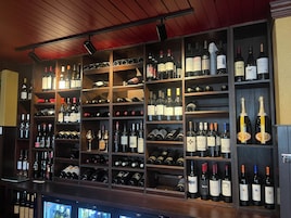 Uma adega com várias prateleiras repletas de garrafas de vinho.