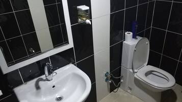 Um polibã, chinelos, um bidé, toalhas fornecidas