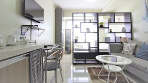 Uma sala de estar moderna com sofá, mesa de centro e TV na parede.