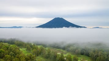 Montanha parcialmente coberta por névoa, com um vale abaixo.