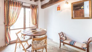 Uma sala de jantar com uma mesa redonda, cadeiras e um banco.