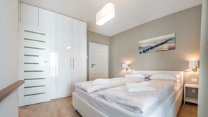 Um quarto moderno com uma cama grande, um guarda-roupa e um quadro na parede.