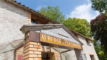 Um edifício com uma placa que diz "AUBERGE du COLOMBIER".
