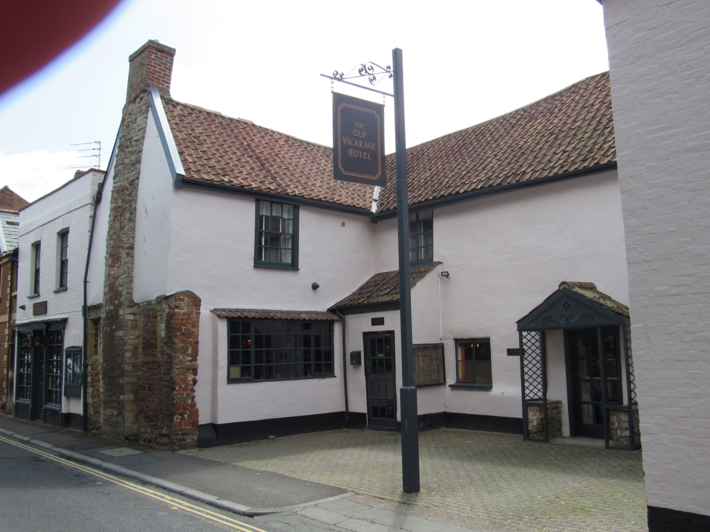 Um edifício tradicional com uma placa que diz "The Old Vicarage Hotel".