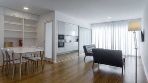 Um apartamento moderno com área de refeições, cozinha e uma grande janela com cortinas.