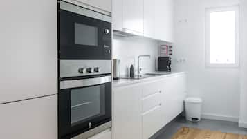 Um frigorífico/congelador grande, um micro-ondas, um forno