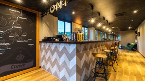 Uma área de bar moderna com um mapa na parede, piso de madeira e banquetas.