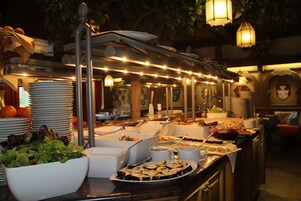 Uma mesa de buffet com diversos alimentos e utensílios de servir.