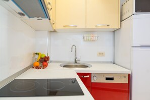 Um frigorífico/congelador grande, um micro-ondas, uma placa de cozinha 