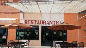 Restaurante com mesas ao ar livre e guarda-sóis.