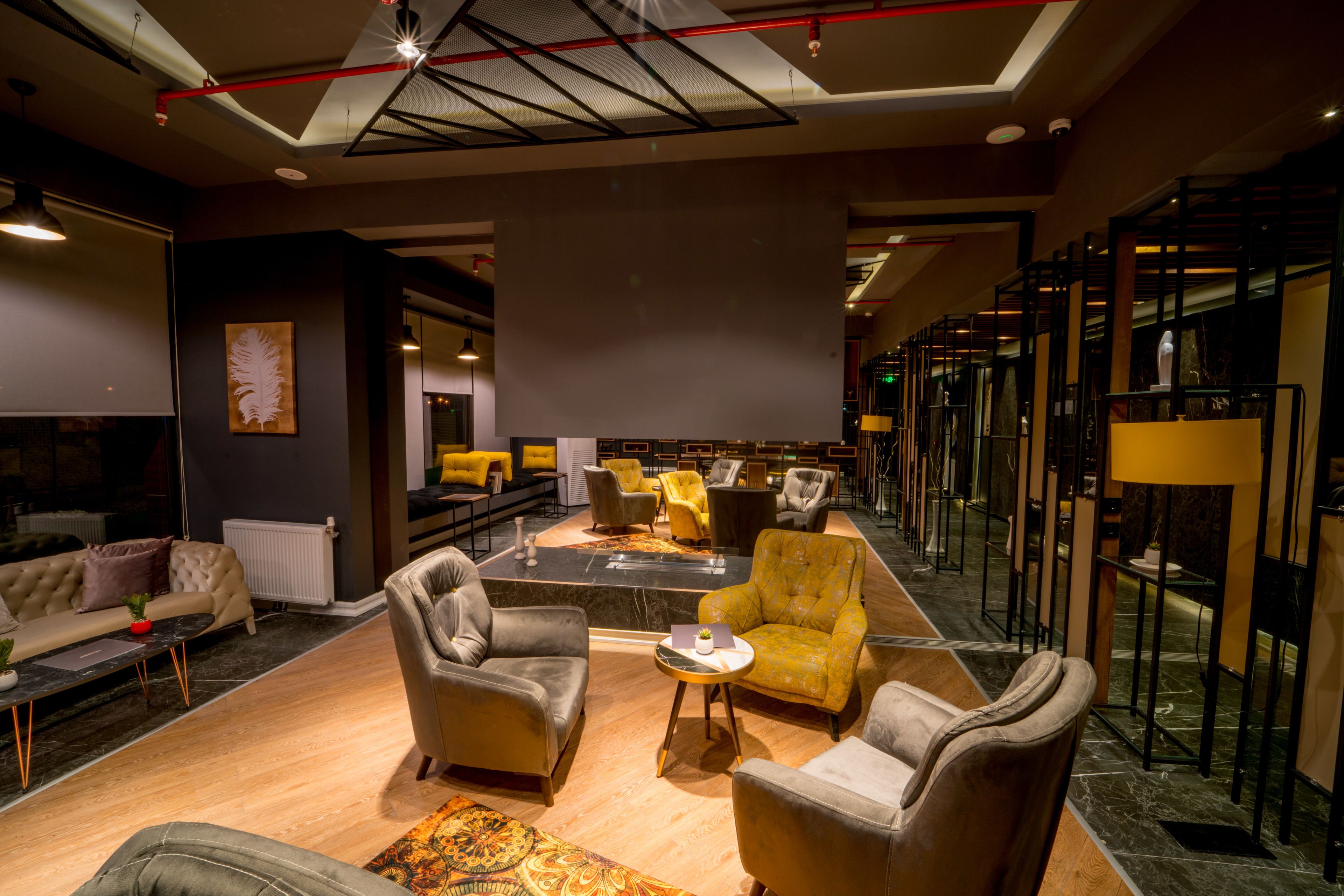 Uma área de estar moderna com sofás, poltronas e uma mesa de centro.