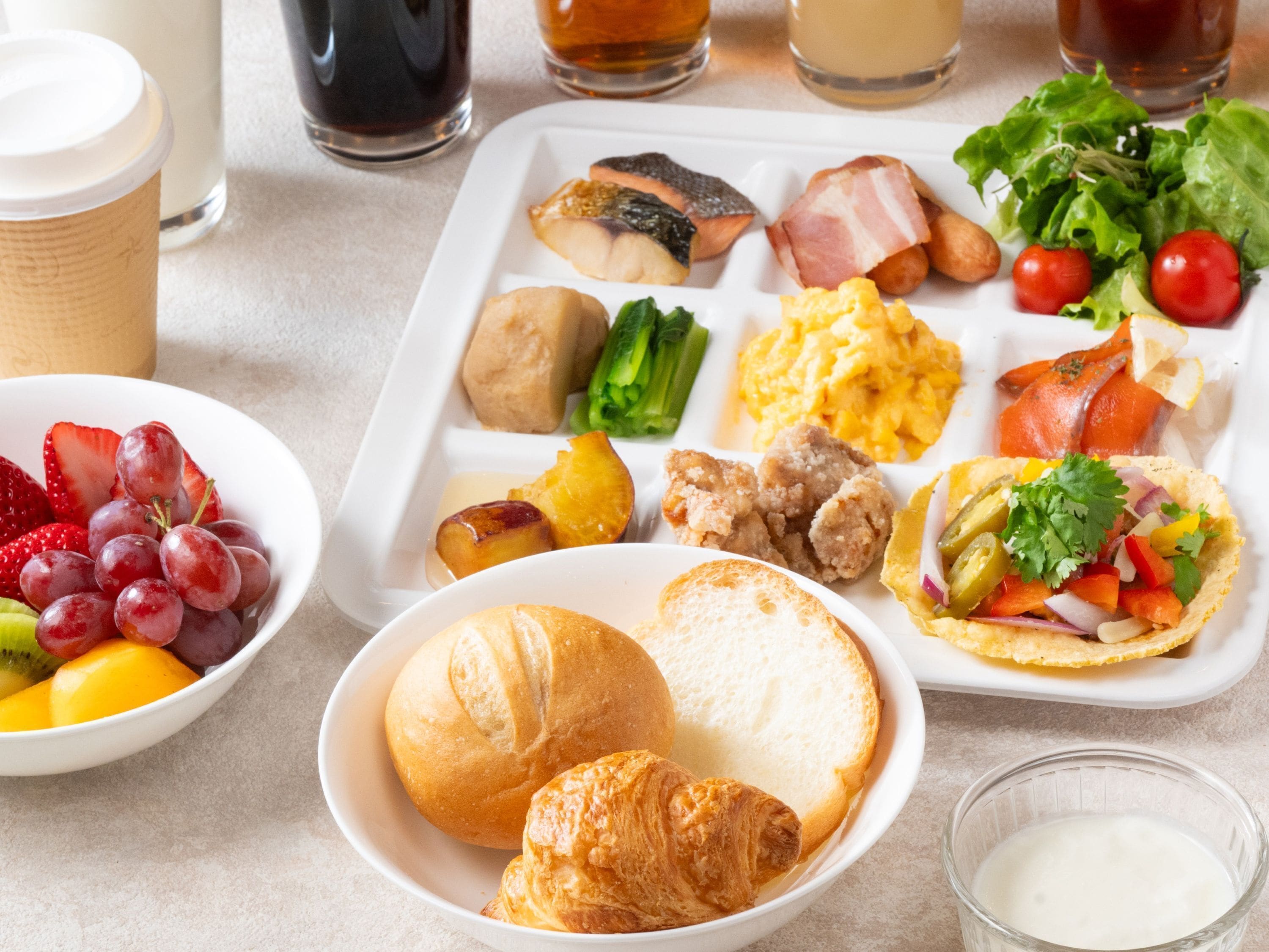 Uma bandeja de café da manhã com diversos alimentos, incluindo ovos, bacon, tomate e uma salada.