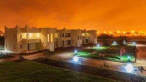 Um edifício moderno com várias varandas e uma entrada bem iluminada.