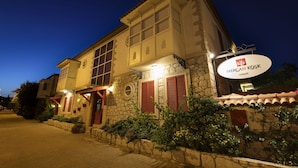 Um edifício de pedra com uma placa que diz 'Mercan Köşk' à noite.