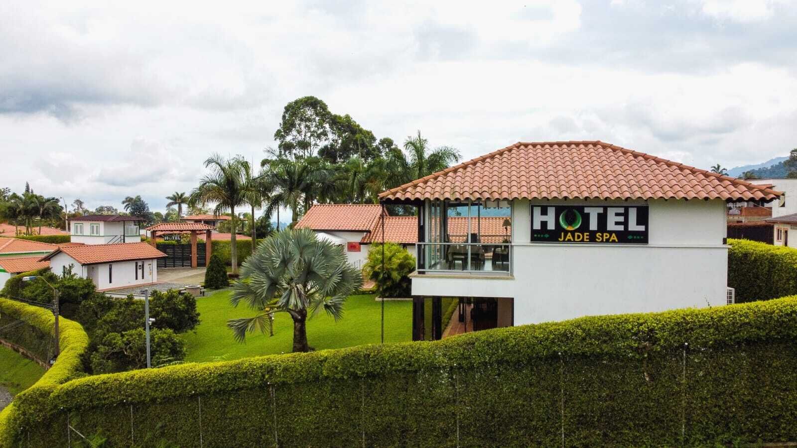 Um hotel com telhado de ladrilho vermelho, uma placa indicando 