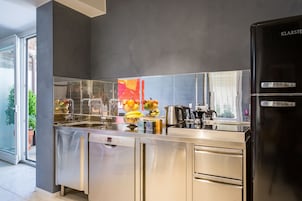 Cozinha moderna com eletrodomésticos de aço inoxidável, lava-louças e geladeira.