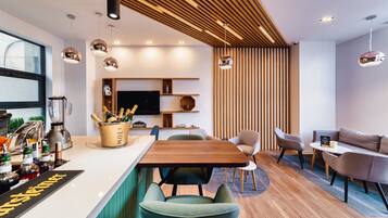 Decoração moderna com teto de madeira, área de bar com garrafas e diferentes opções de assento.