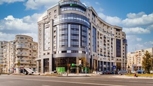 Um hotel moderno com fachada curva, janelas amplas e um destaque para a placa Holiday Inn.