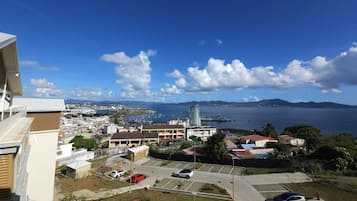 Paisagem urbana costeira com edifícios, um porto de iates e céu claro.