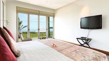 Quarto com uma cama grande, televisão e vista para o exterior.