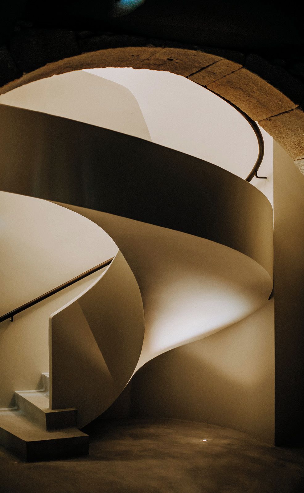 Escada em espiral com design moderno, apresentando uma curva contínua e um corrimão.
