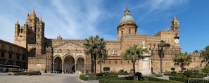 Um edifício histórico com uma grande cúpula, entradas em arco e estátuas.