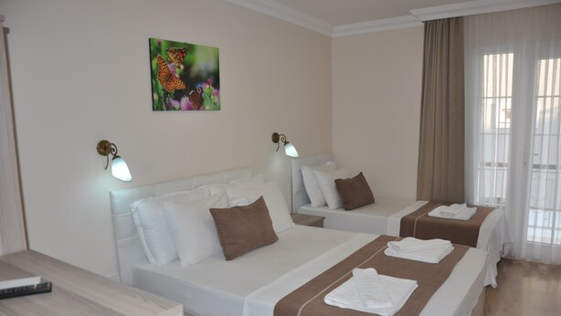 Quarto de hotel com duas camas, uma escrivaninha e um quadro na parede.