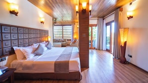 Um quarto de hotel espaçoso, com uma cama grande, teto de madeira e várias arandelas.