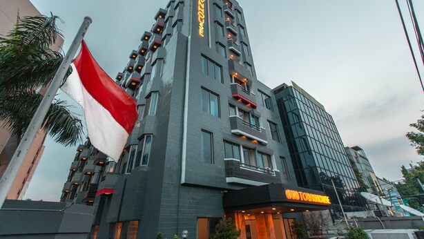 Um hotel moderno com vários andares, varandas e uma bandeira destacada.