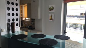 Uma cozinha moderna com uma ilha de vidro, armários brancos e obras de arte na parede.
