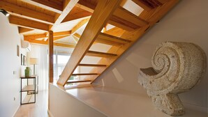 Um interior moderno com teto inclinado, uma escultura em pedra e design minimalista.