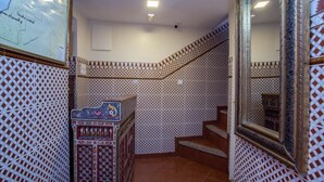 Uma escadaria com paredes estampadas e um banco de madeira decorativo.