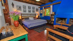 Quarto com cama, móveis de madeira, lareira e estante de livros.
