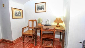 Uma sala de jantar com uma mesa e cadeiras de madeira, um vaso com flores e quadros nas paredes.