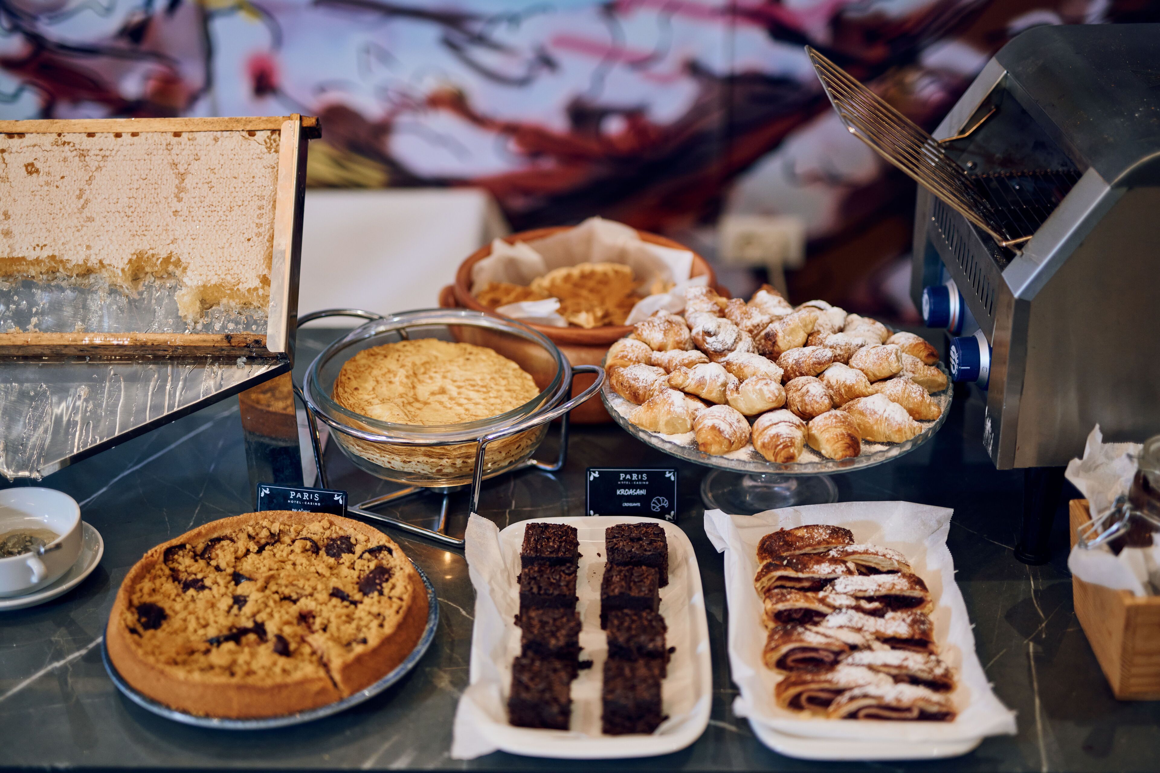 Diversos produtos de panificação expostos em um balcão, incluindo tortas, doces e brownies.