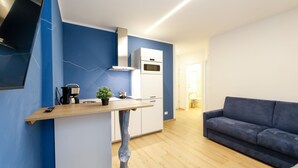 Uma cozinha moderna com forno embutido, bancada de madeira e parede azul decorativa.