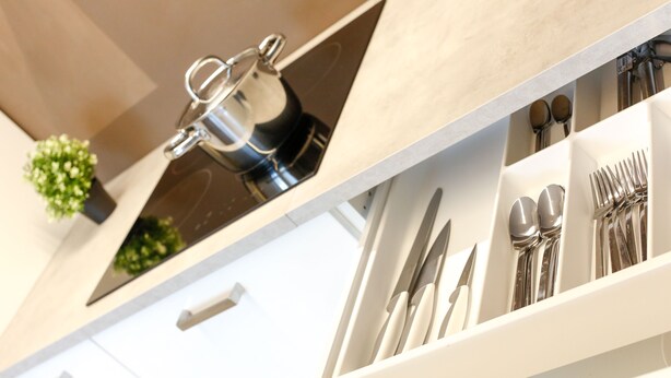 Uma cozinha moderna com máquina de café integrada e gaveta para utensílios.