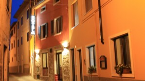 Uma rua estreita ladeada por edifícios, com varandas e janelas.