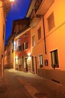 Uma rua estreita ladeada por edifícios, com varandas e janelas.