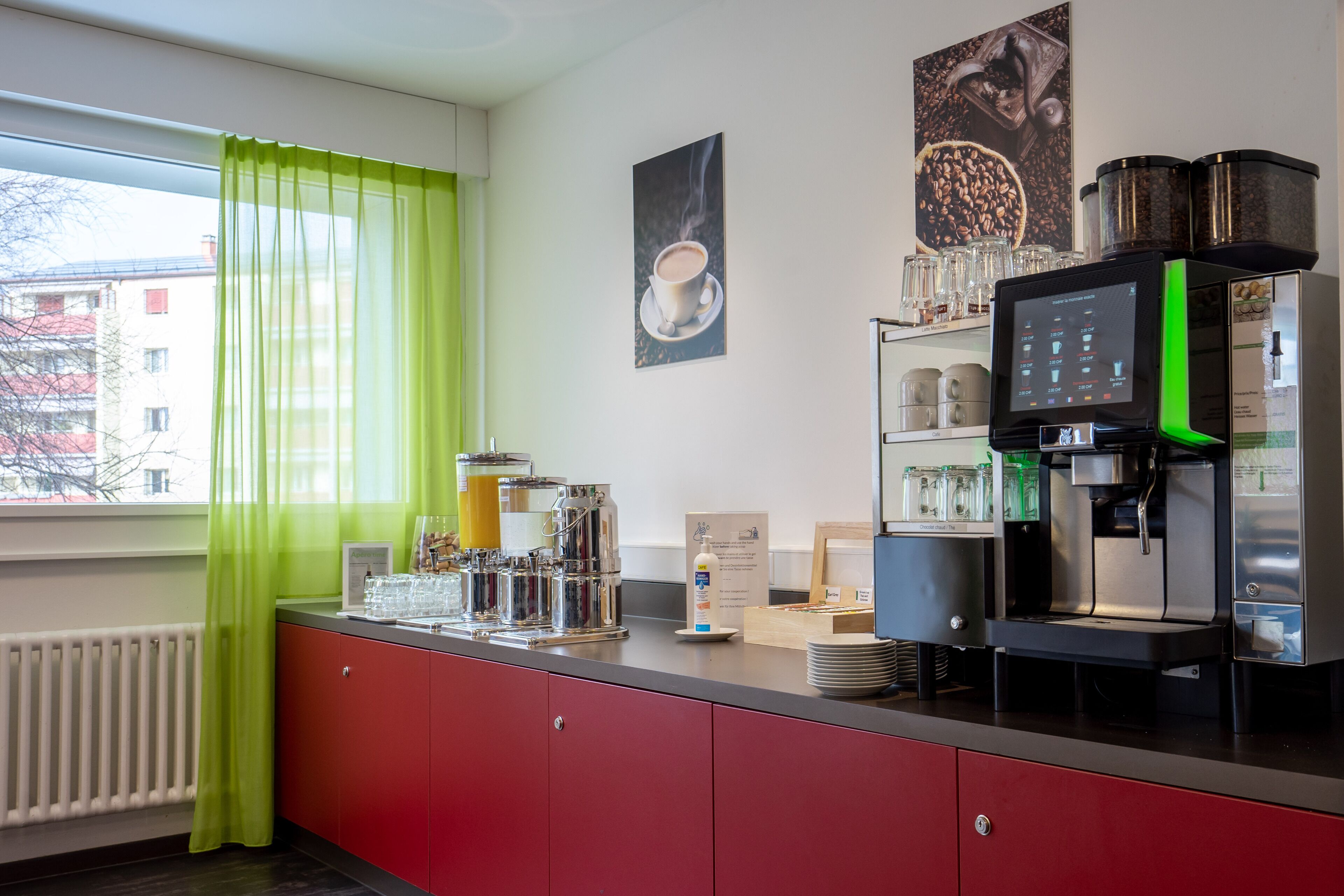 Uma estação de café moderna, com máquina de café, copos e um quadro de cardápio.