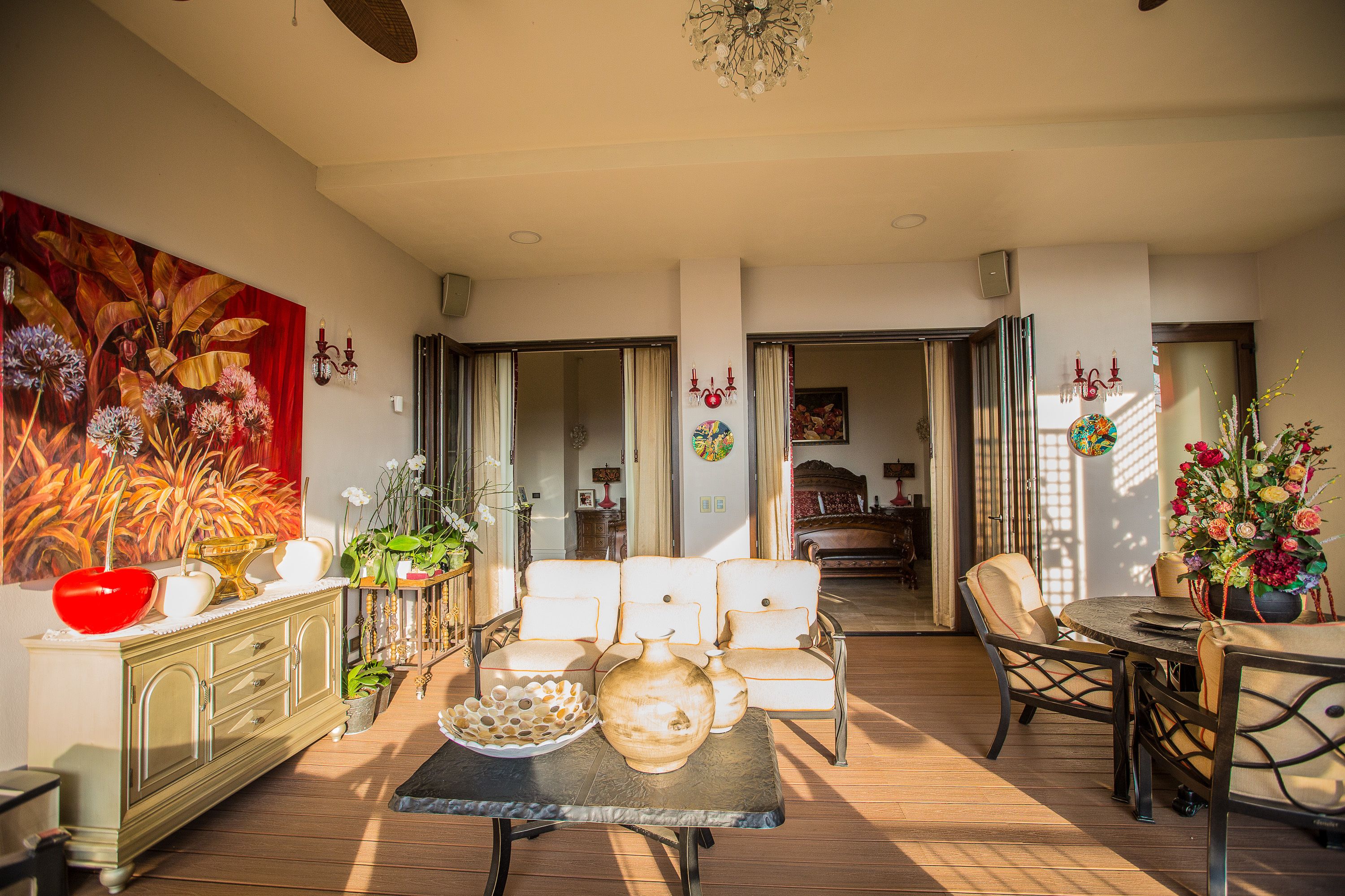Uma sala ampla com um conjunto de sofás, uma mesa de jantar e um quadro grande na parede.