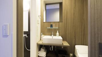 Casa de banho moderna com lavatório branco, espelho e porta-toalhas.