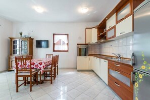 Uma placa de cozinha, uma máquina de lavar louça, utensílios de cozinha