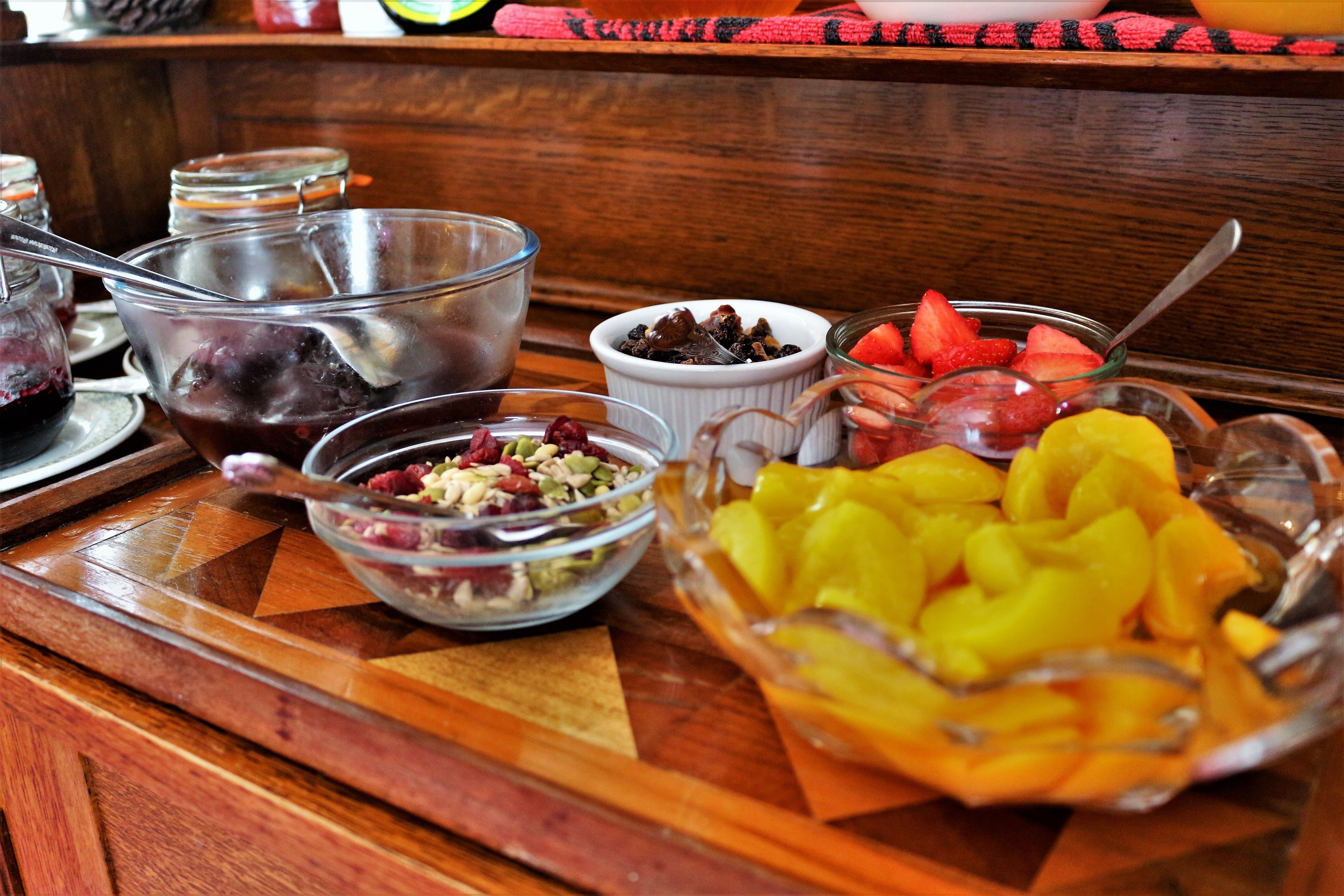 Um buffet de café da manhã com diversas frutas em tigelas e uma mesa de madeira.
