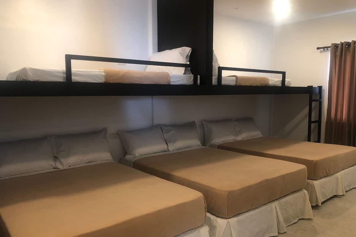 Uma cama beliche com duas camas de baixo e uma cama superior.