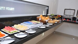 Um buffet com diversos alimentos e utensílios.