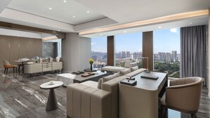 Sala de estar moderna com sofá, mesa de centro e área de jantar, com vista para a cidade.