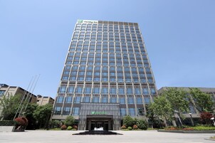 Um hotel moderno com fachada imponente, vários andares e entrada destacada.