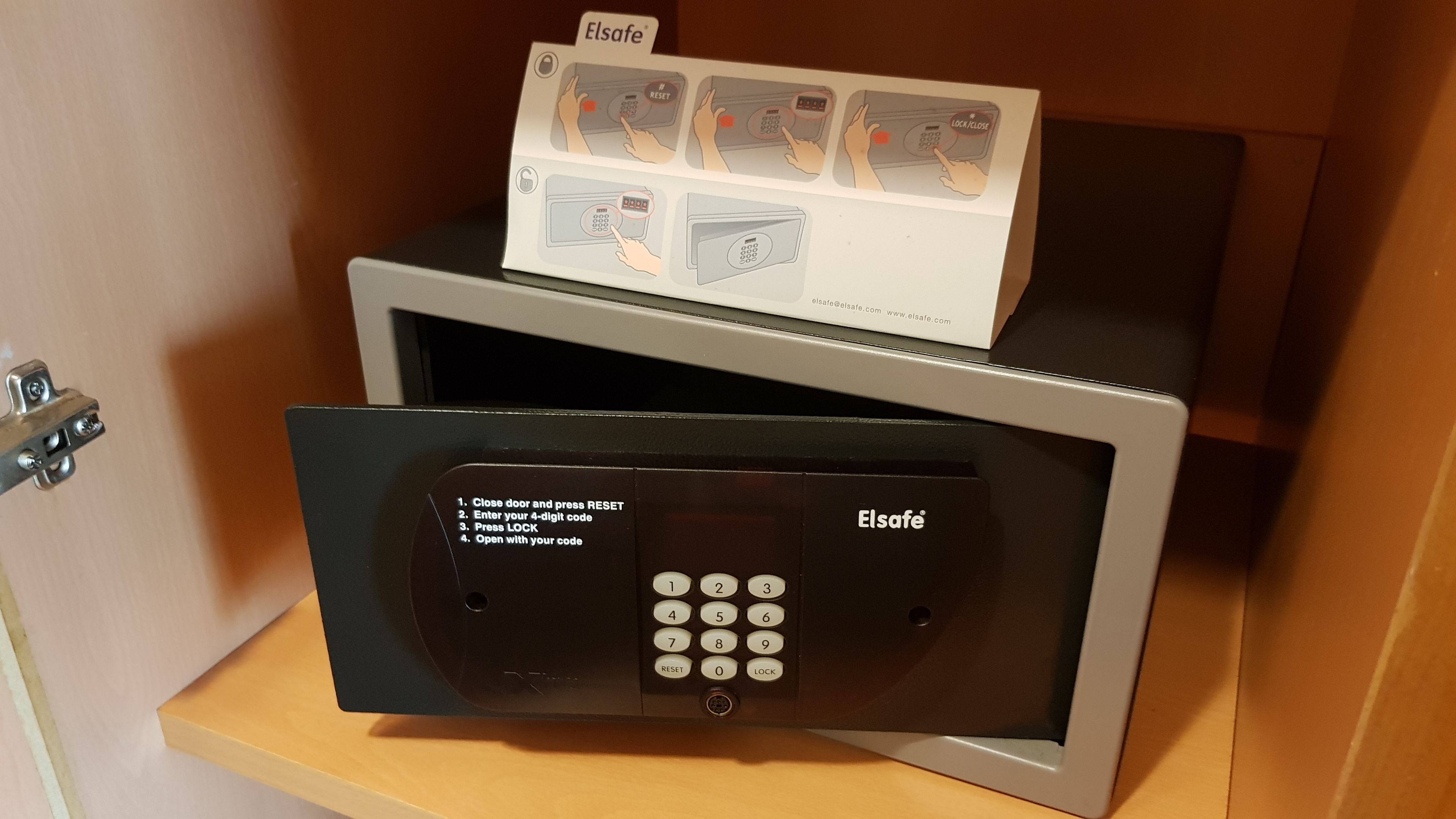 Uma porta com fechadura eletrônica e fechadura manual. Instruções para usar a fechadura eletrônica estão exibidas na porta.