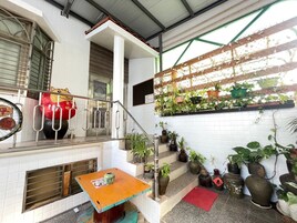 Uma escadaria com plantas em vasos, uma pequena mesa com uma xícara e uma estátua decorativa de sapo.